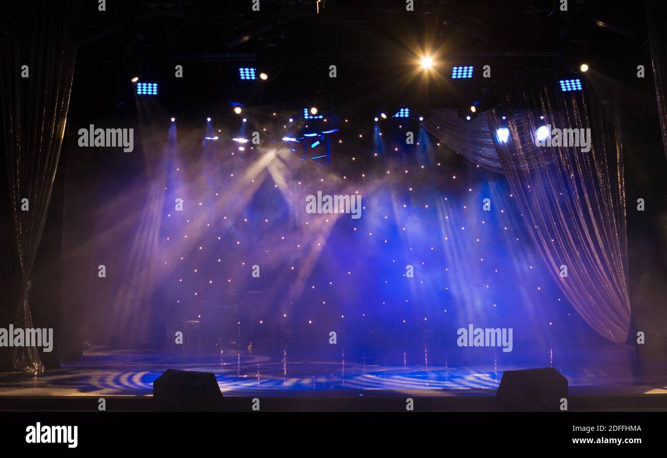 An empty stage of the theater, lit by spotlights and smoke before the ...