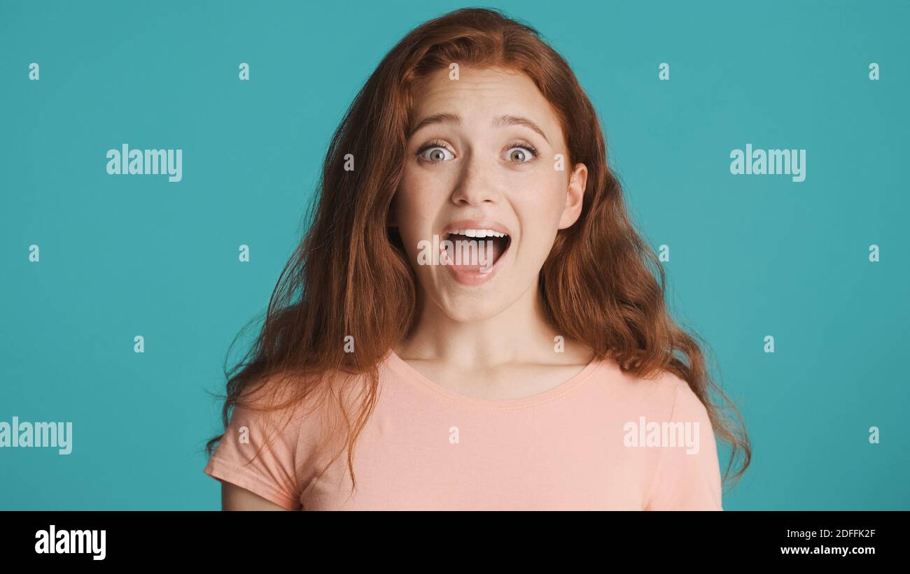 Attractive excited girl surprisingly looking in camera over colorful ...