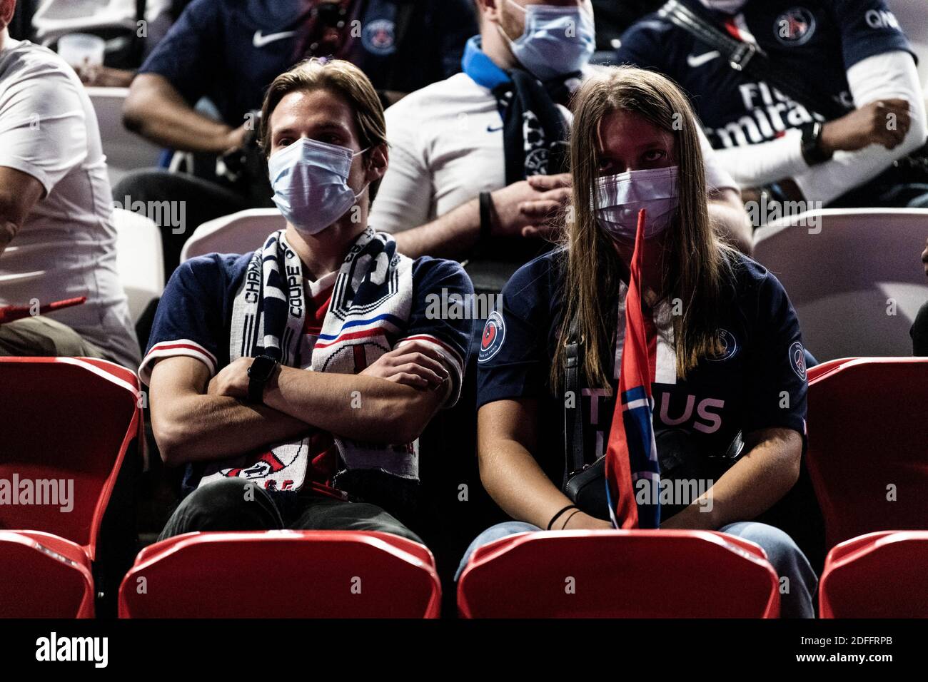 Paris Saint-Germain (PSG) supporters wearing face masks react after ...