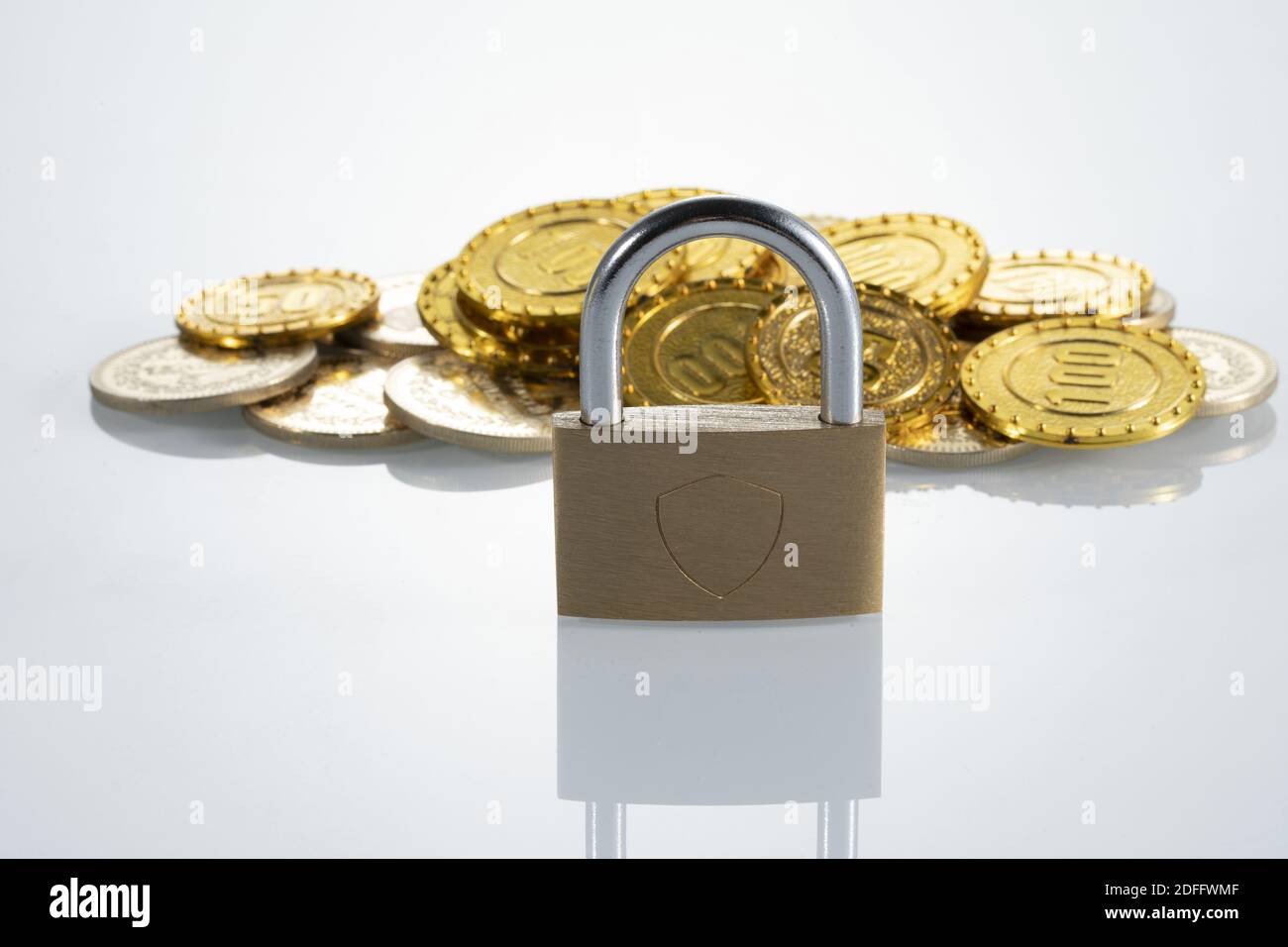 A padlock with a pile of coins in the backgrou- secure banking concept ...