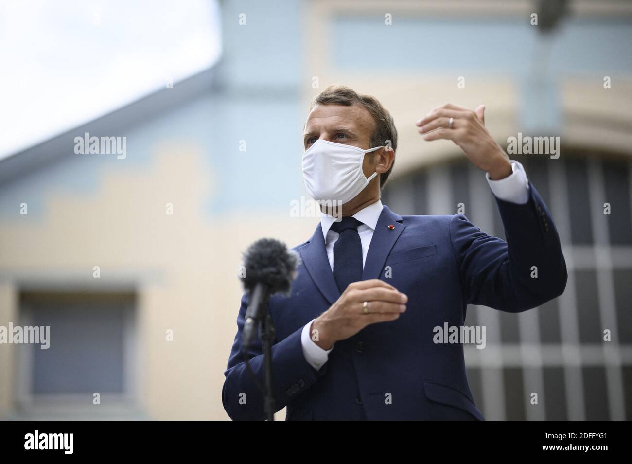 French President Emmanuel Macron, wearing a protective face mask ...