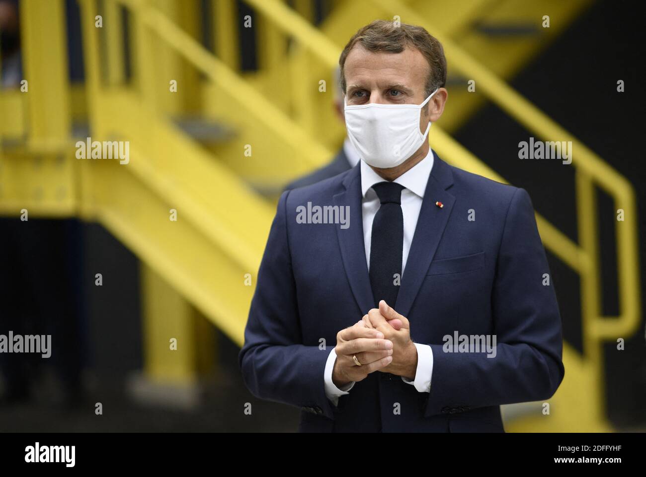 French President Emmanuel Macron, wearing a protective face mask ...