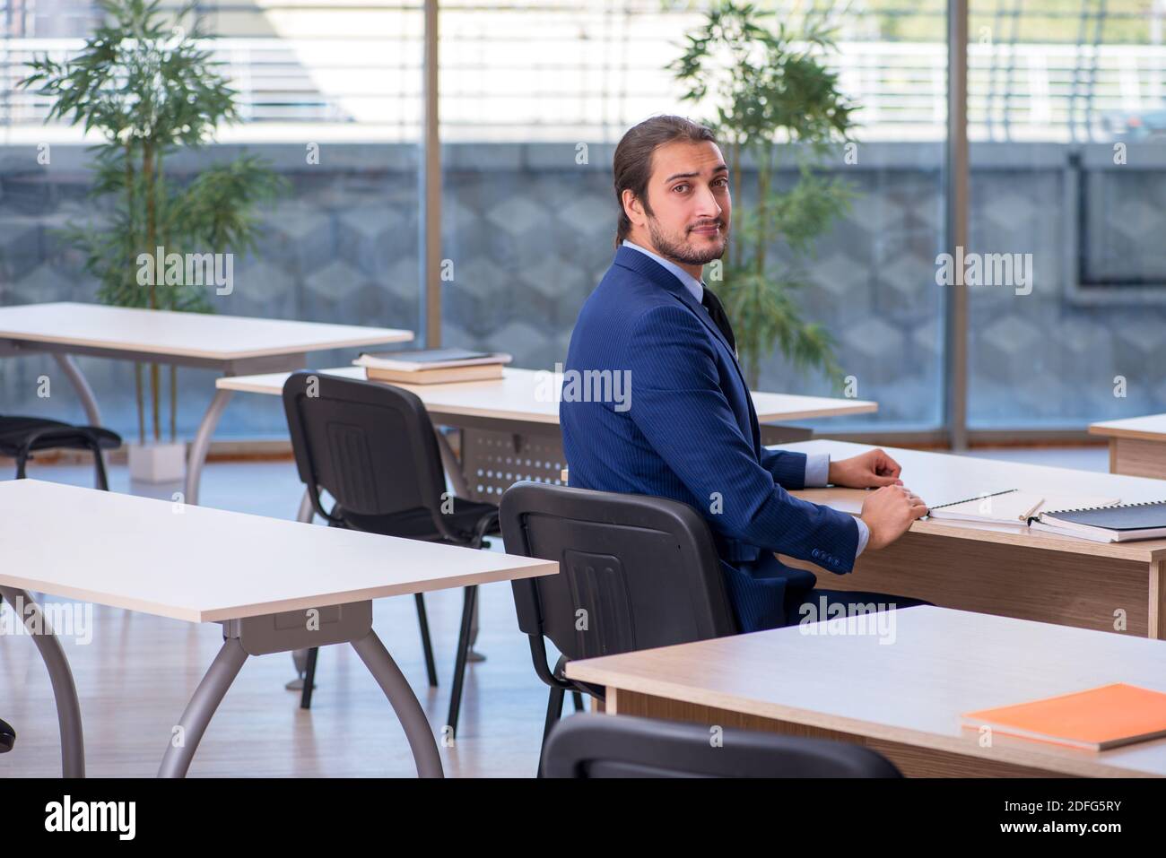 Young teacher in suit in the classroom Stock Photo - Alamy