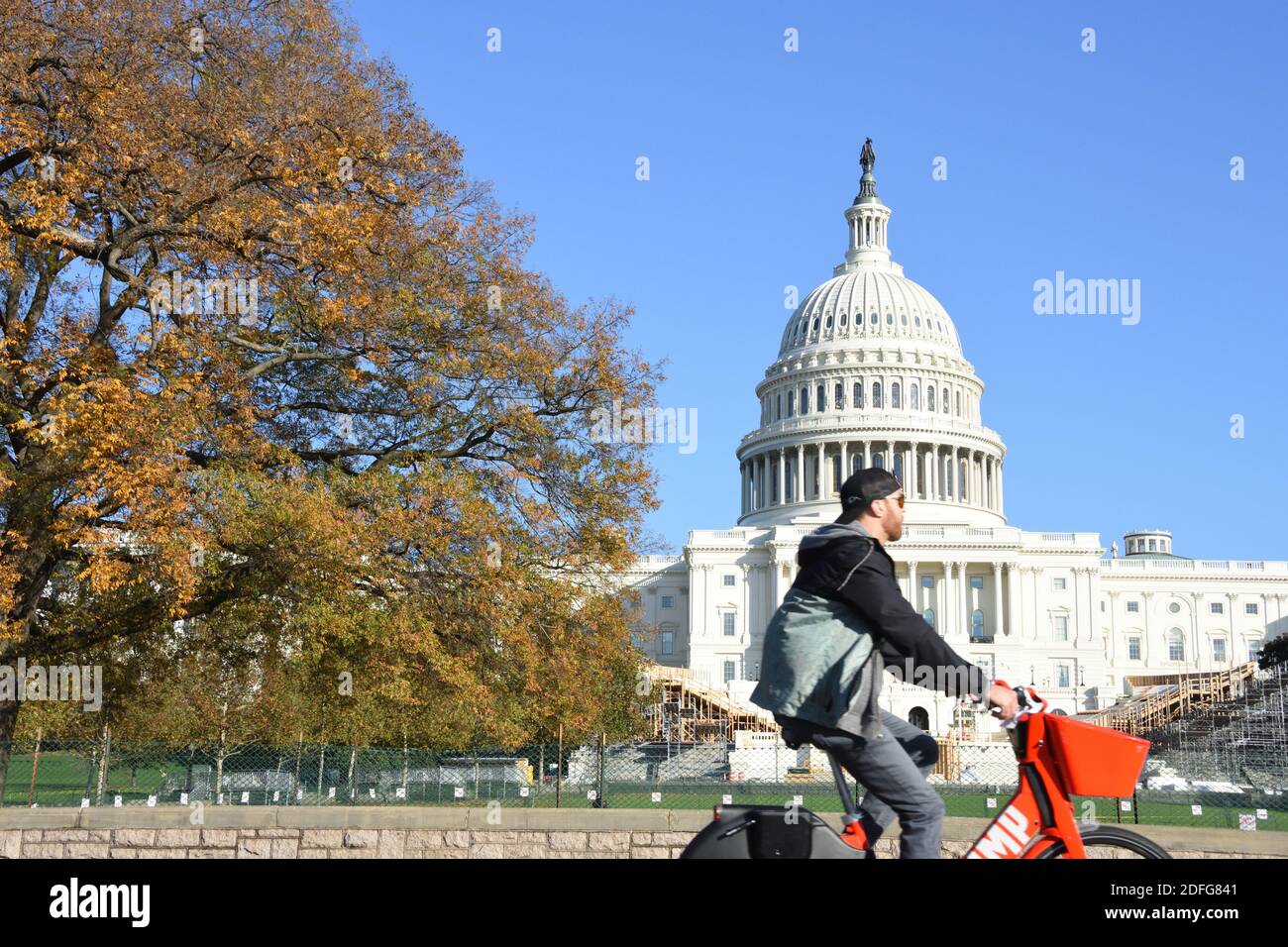 A man riding red rental bike JUMP in front of the US Capitol building ...