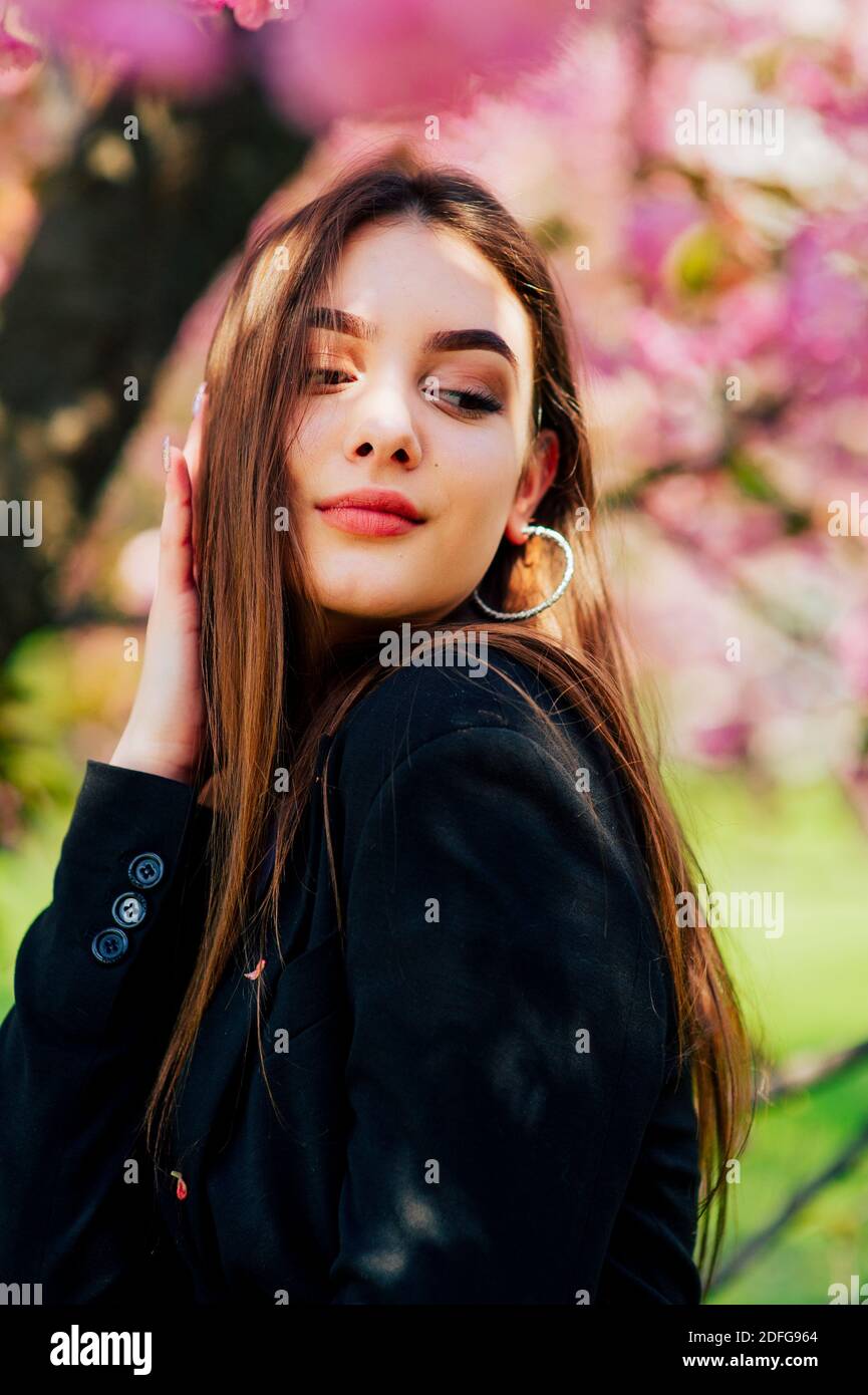 girl with long hair enjoys the beauty of spring nature near the ...