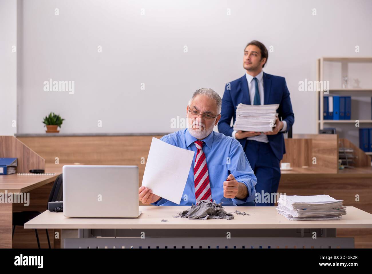 Male employee and his old boss burning papers at workplace Stock Photo ...