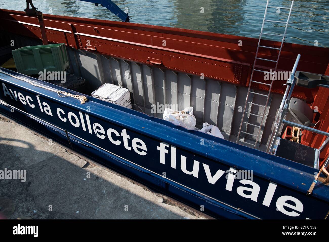 Workers move garbage on a barge during the launch of the riverside ...