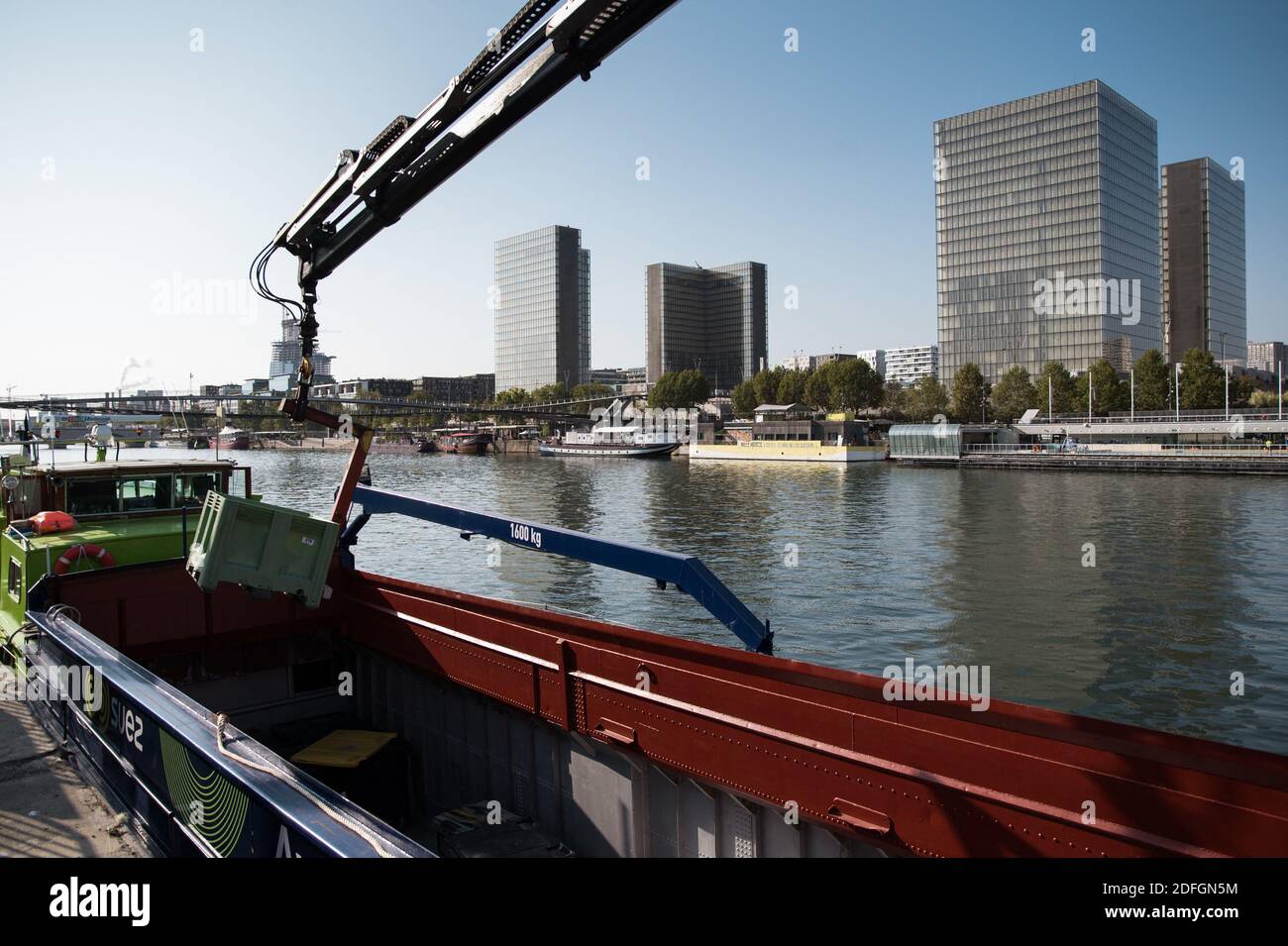 Workers move garbage on a barge during the launch of the riverside ...