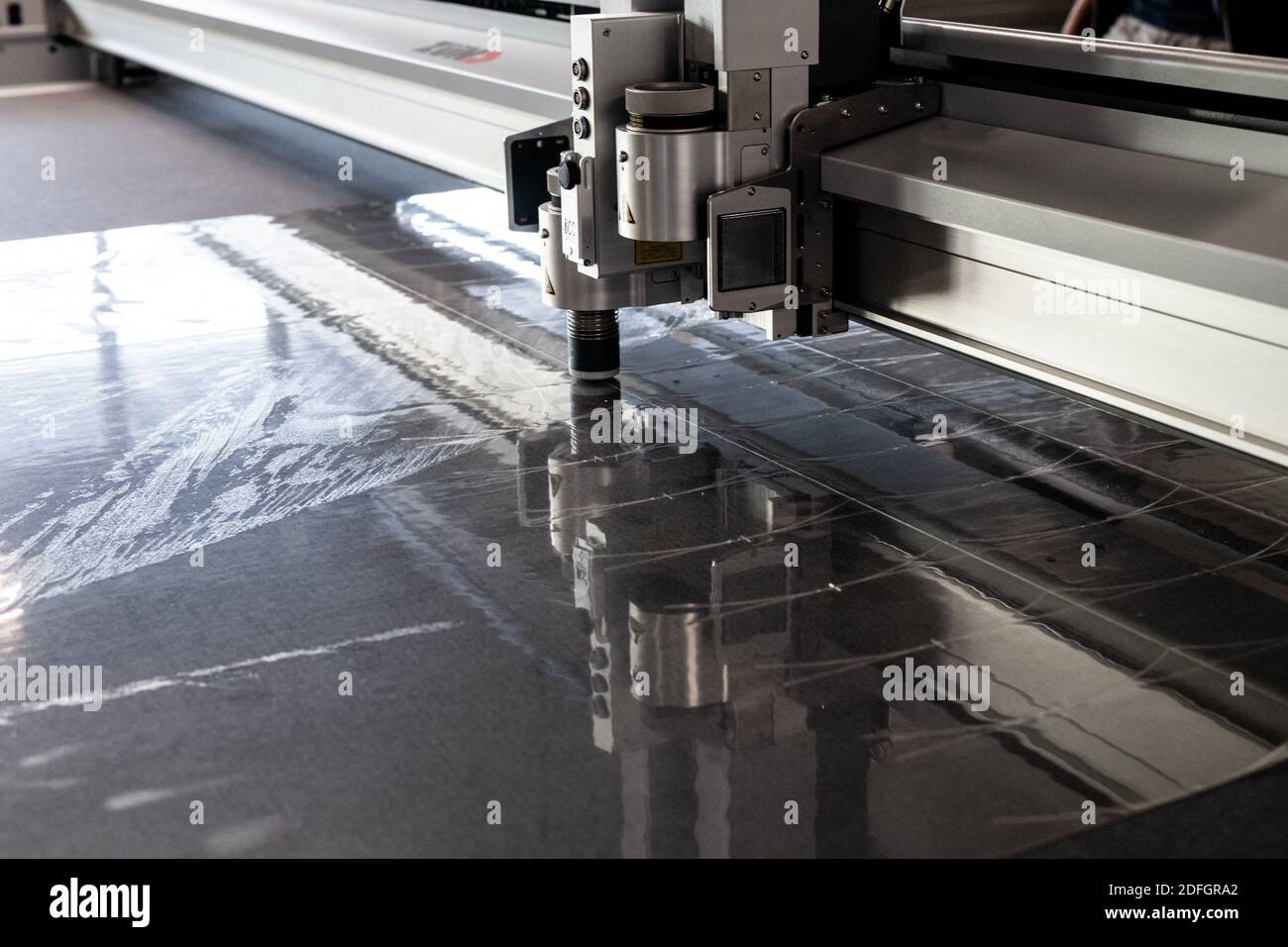 A digital die cutter cuts plastic for a visor for a Masque Inclusif ...