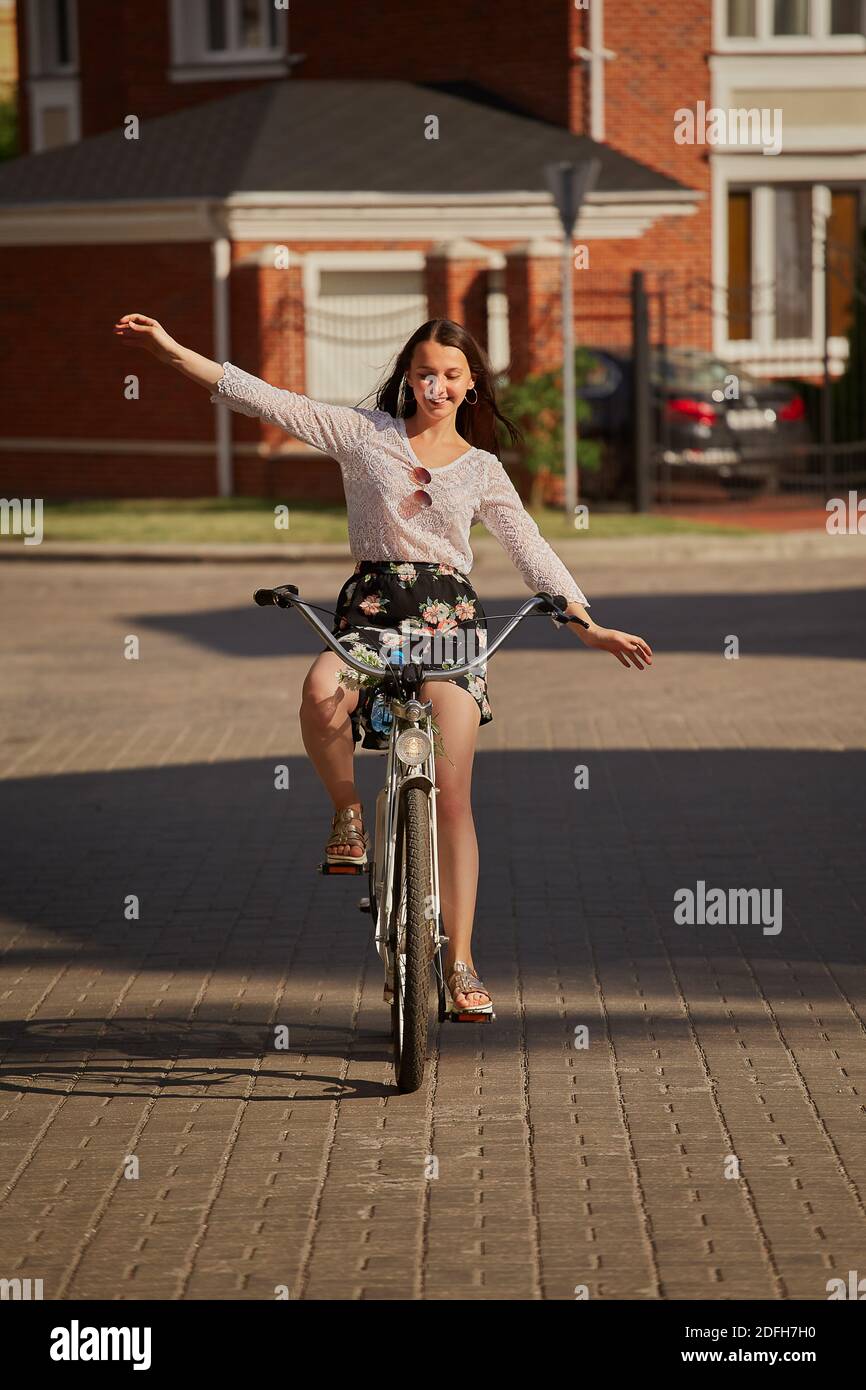 happy girl move on bicycle on street under sun rays Stock Photo - Alamy
