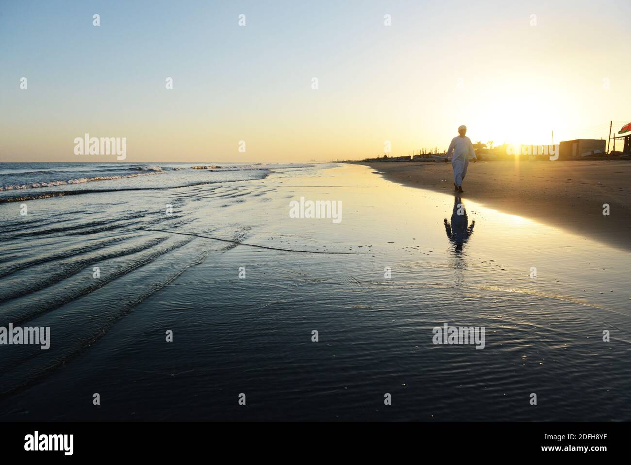 An Omani man walking on th Barka beach in Oman Stock Photo - Alamy