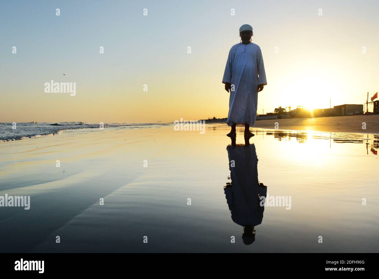 An Omani man walking on th Barka beach in Oman Stock Photo - Alamy
