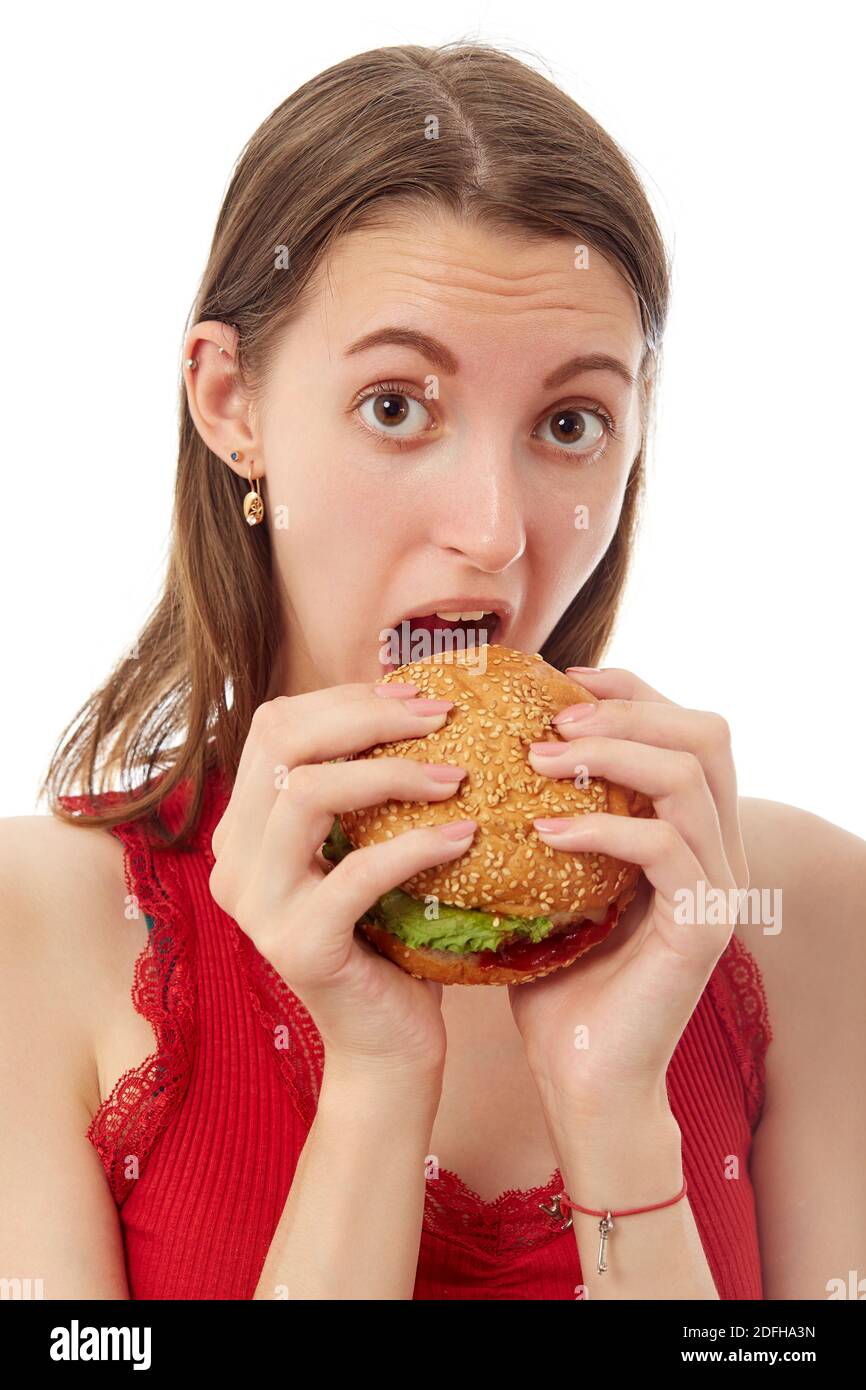 happy young woman eats cheeseburger on white background isolated ...
