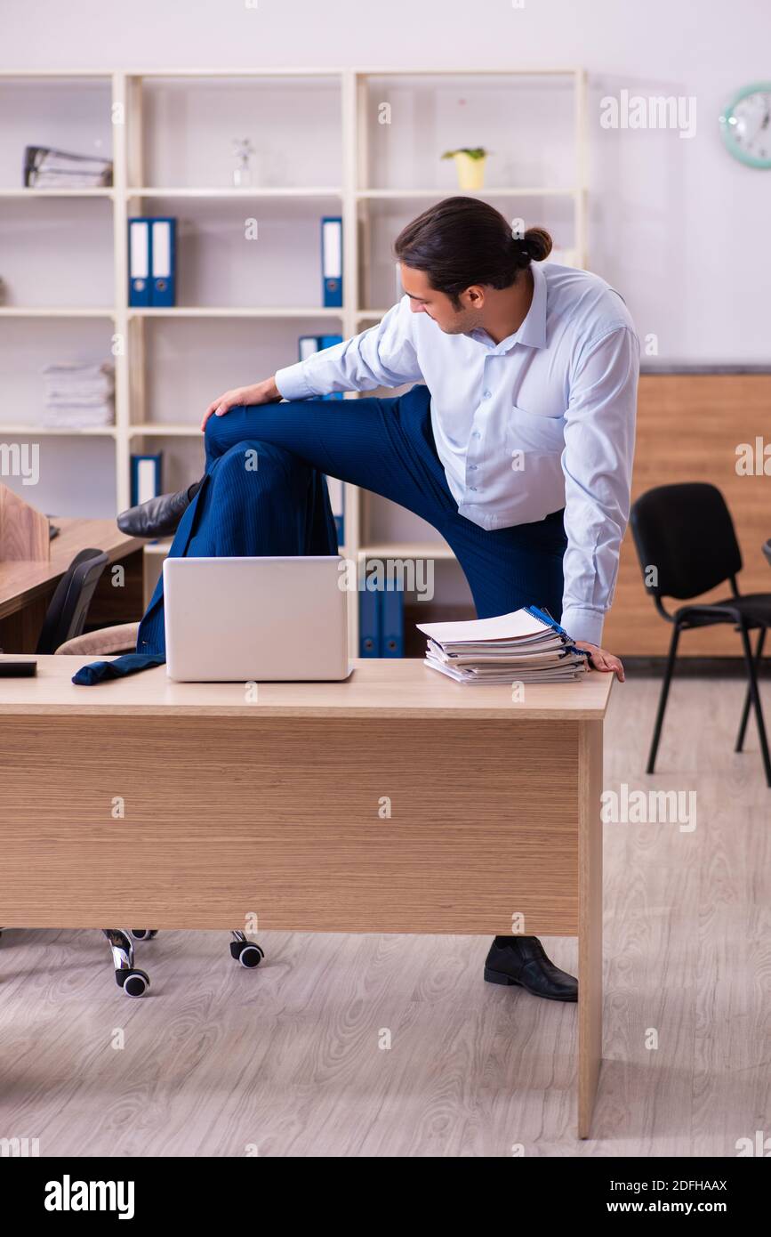 Young employee doing physical exercises at workplace Stock Photo - Alamy