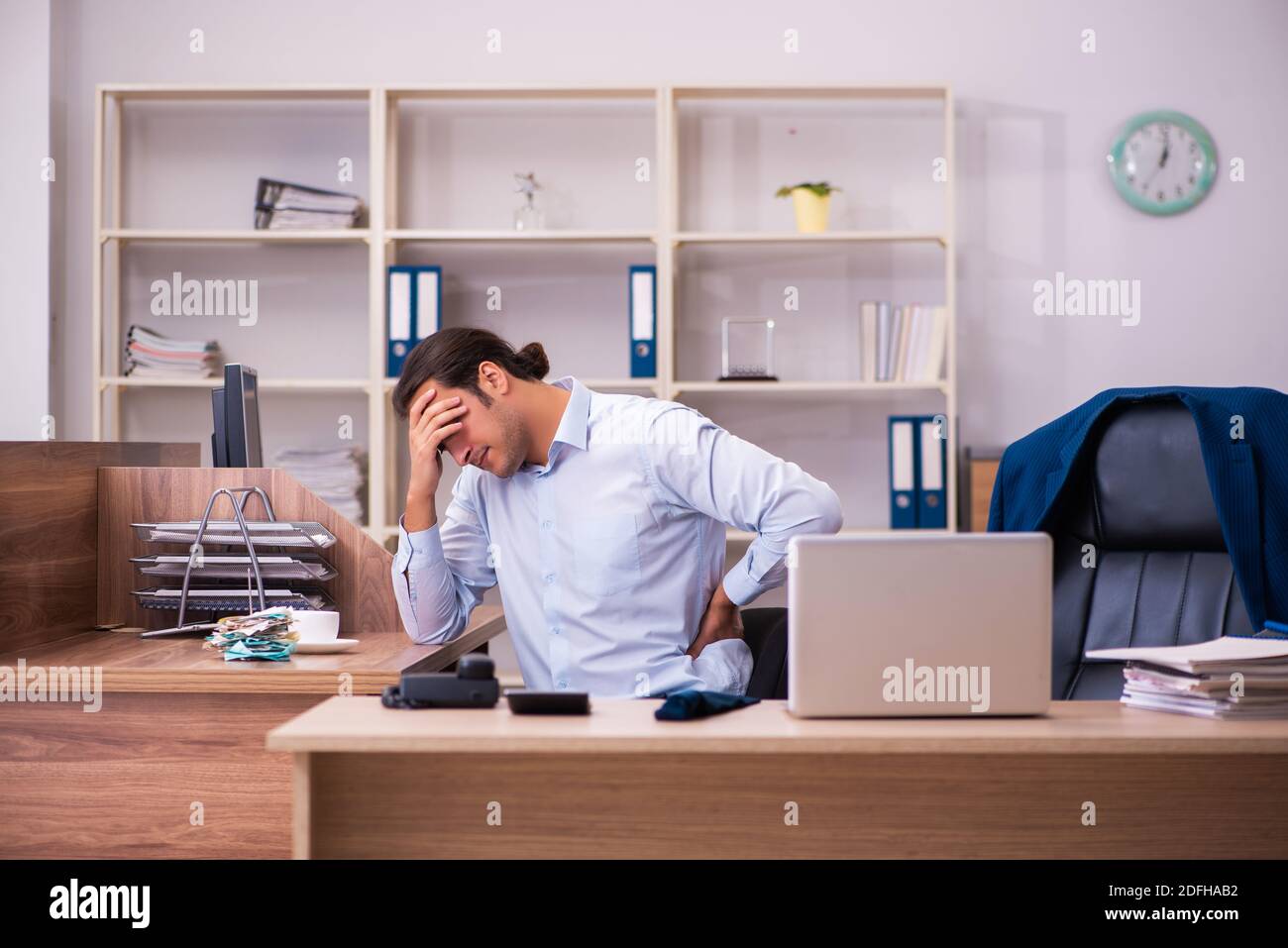 Young employee suffering from backpain at workplace Stock Photo - Alamy