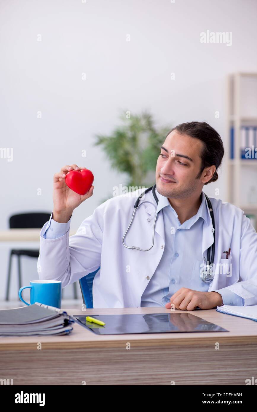 Young doctor cardiologist holding heart model Stock Photo - Alamy