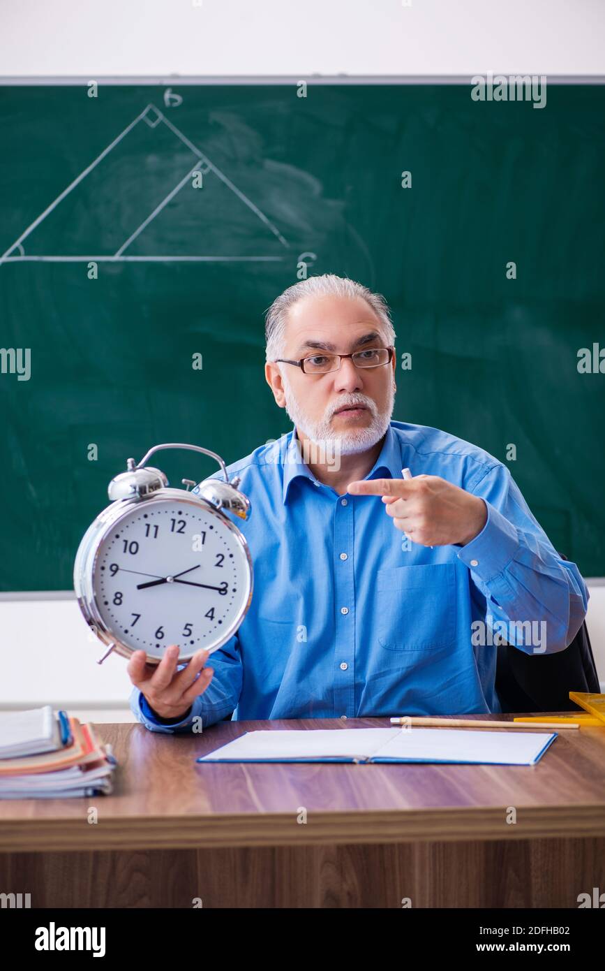 Senior male math teacher in time management concept Stock Photo - Alamy