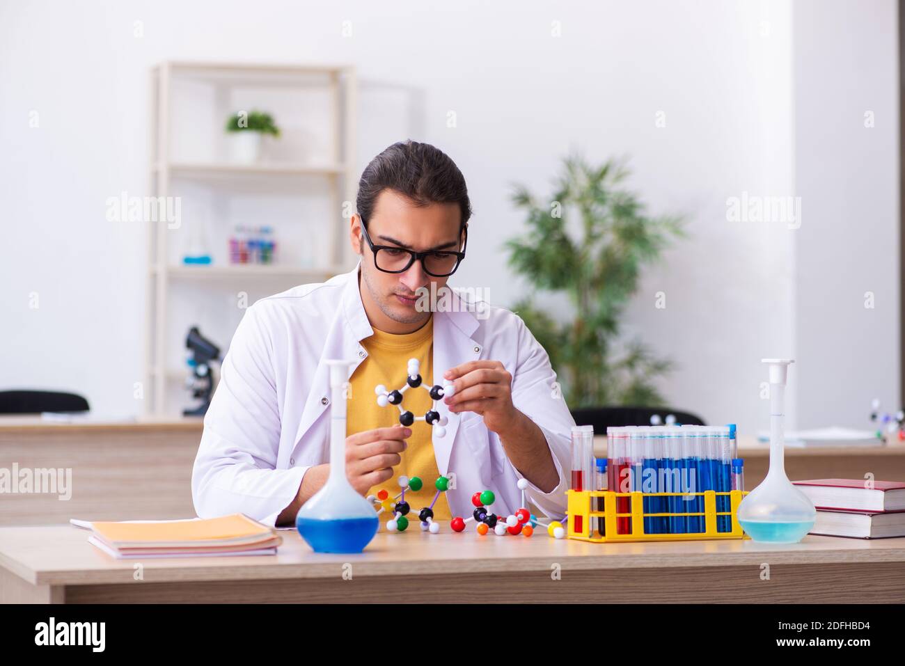 Young chemist studying molecular model in the classroom Stock Photo - Alamy