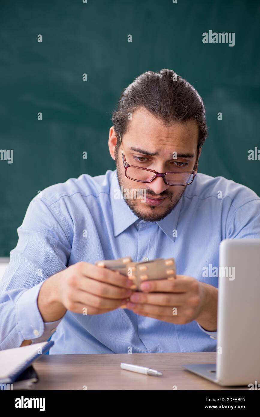Young sick teacher in the classroom Stock Photo - Alamy