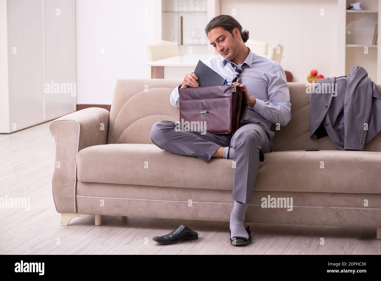 Tired businessman coming home after working day Stock Photo - Alamy
