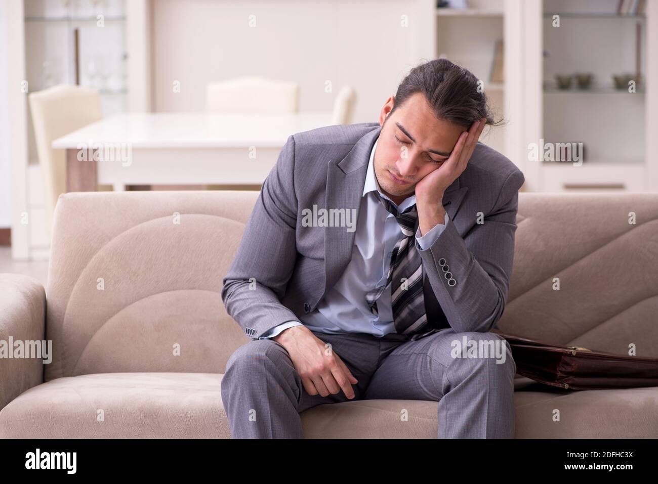 Tired businessman coming home after working day Stock Photo - Alamy