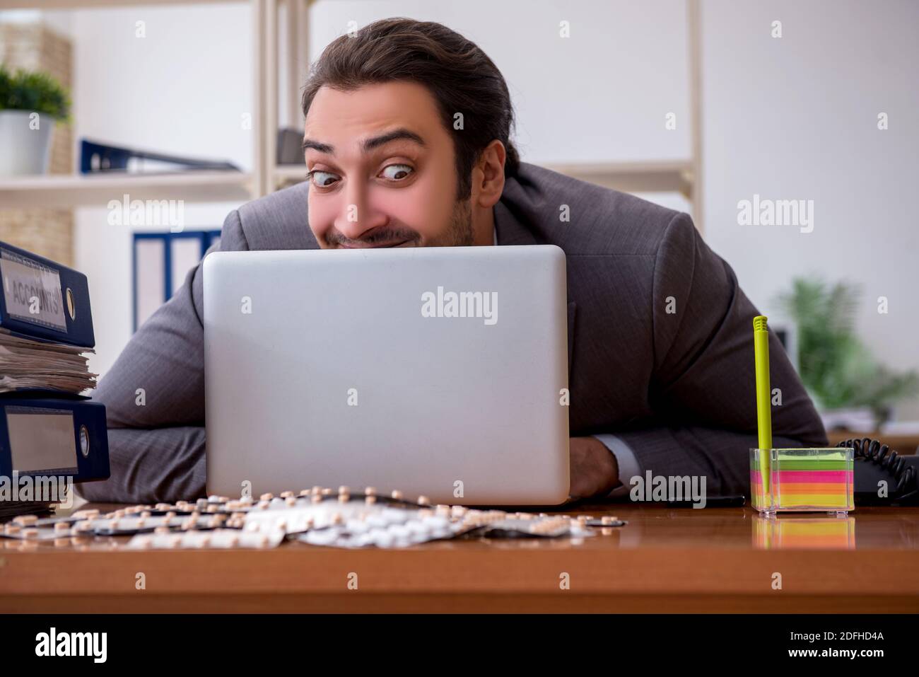 Male sick employee suffering at workplace Stock Photo - Alamy
