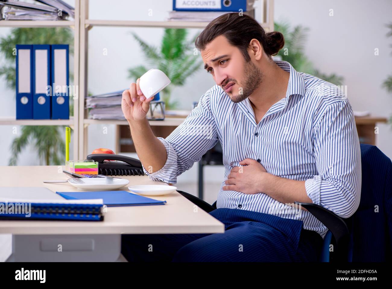 Hungry employee waiting for food at workplace Stock Photo - Alamy