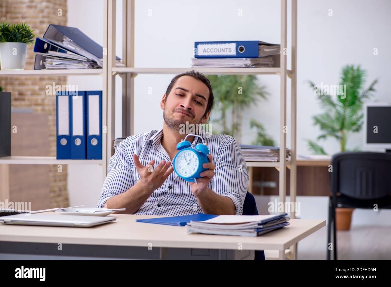 Hungry employee waiting for food in time management concept Stock Photo ...