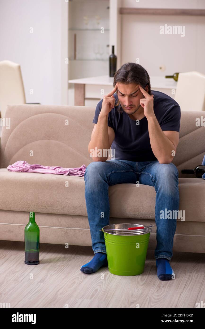 Young addicted man suffering from stomachache at home Stock Photo - Alamy