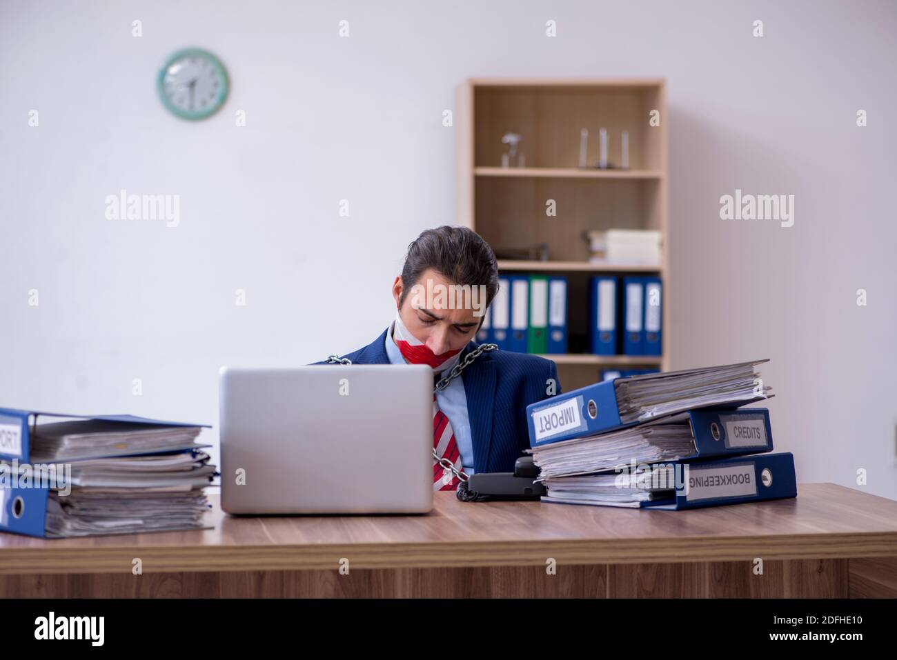 Chained employee unhappy with excessive work in the office Stock Photo ...