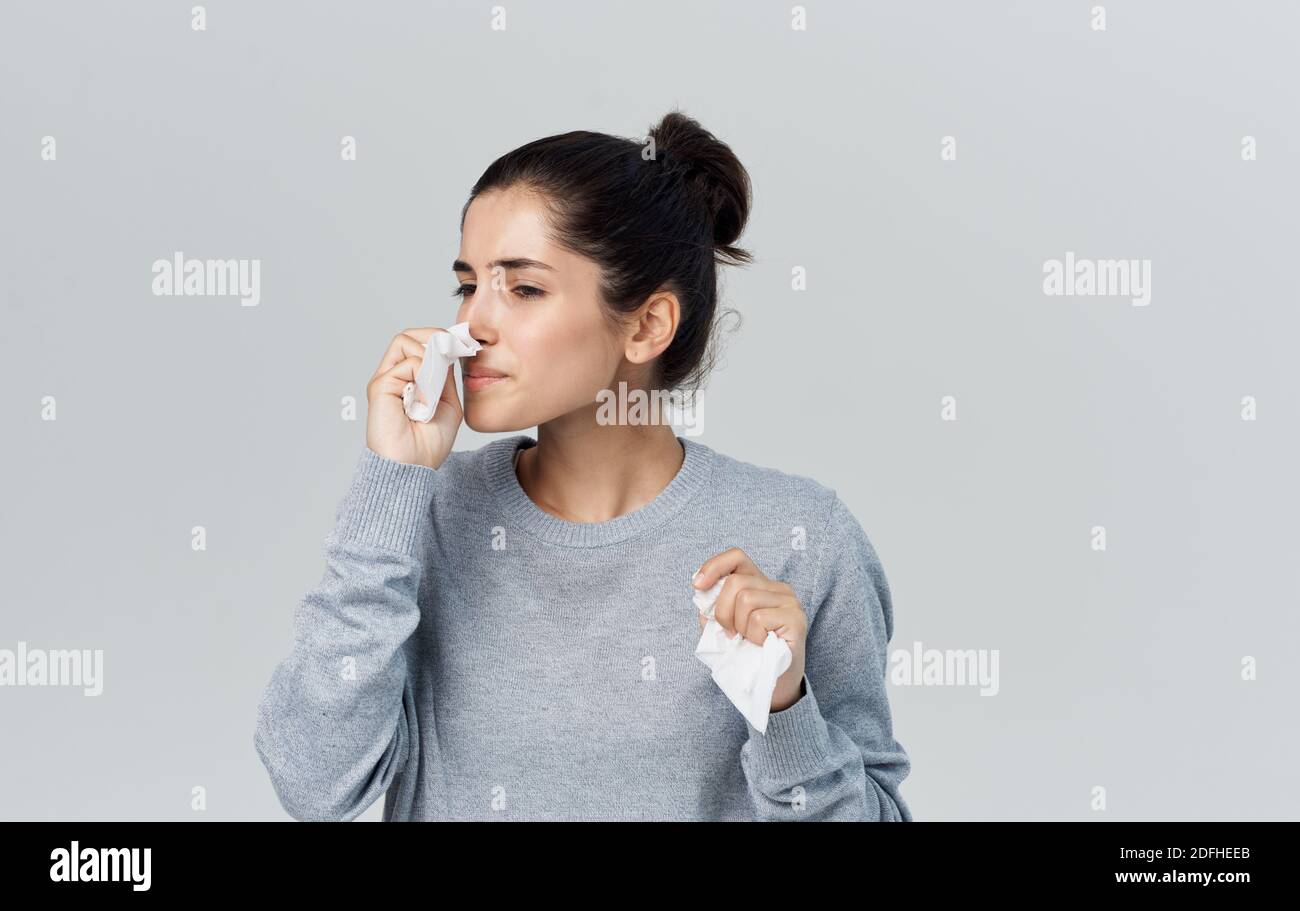 Woman in sweater holding napkin near face with runny nose health ...