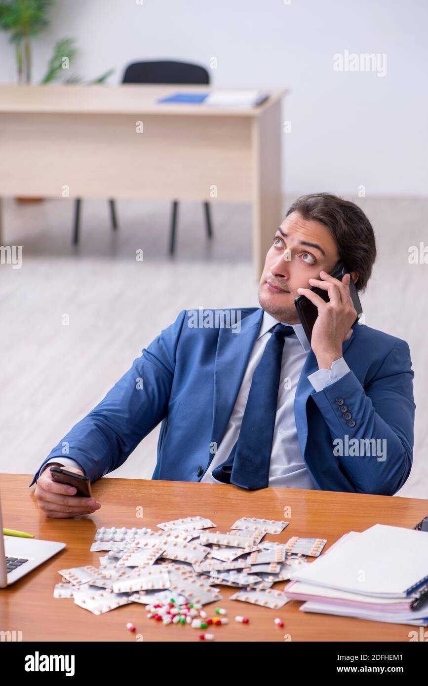 Sick male employee suffering at workplace Stock Photo - Alamy