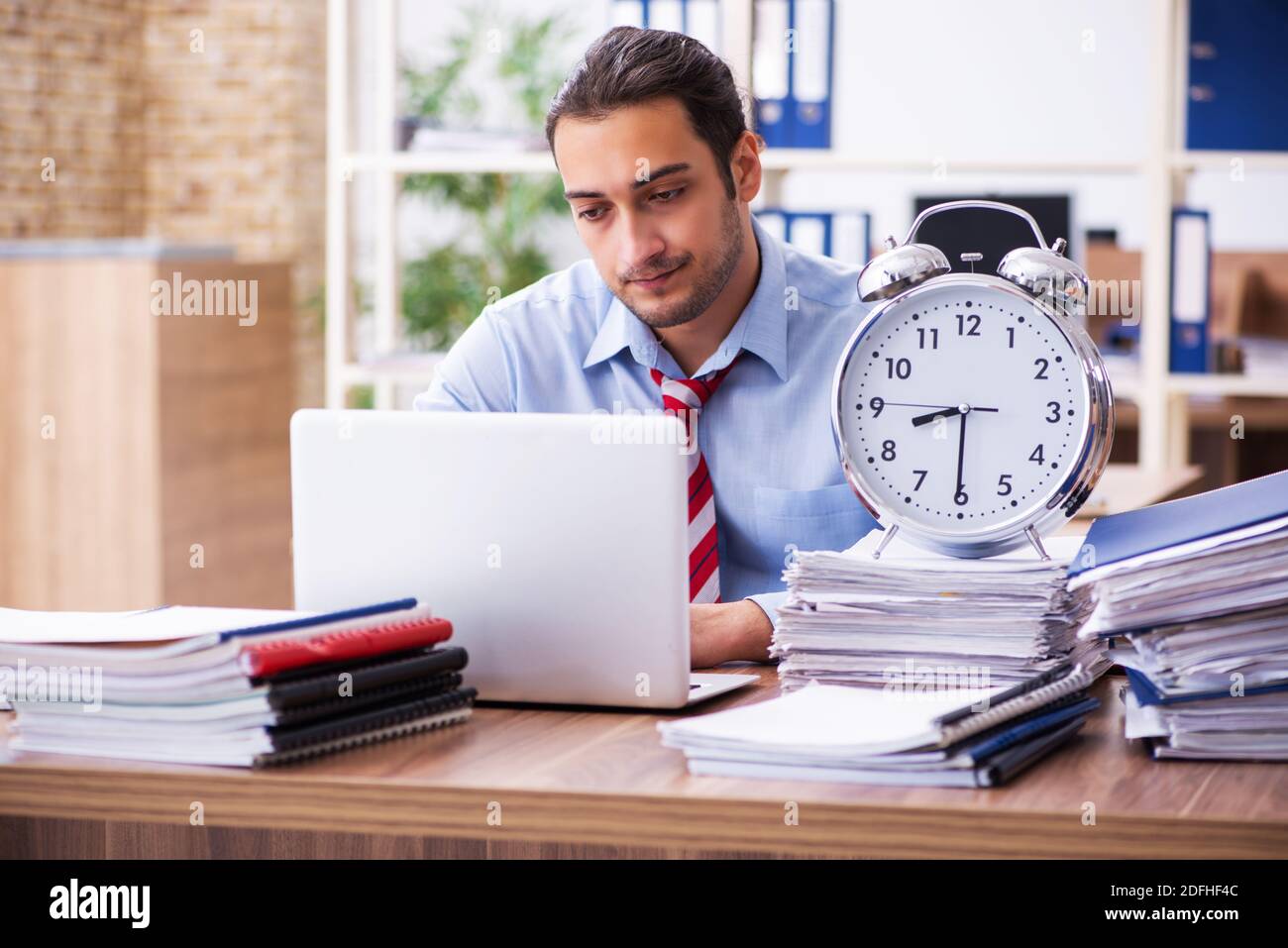 Young employee unhappy with excessive work in time management concept ...