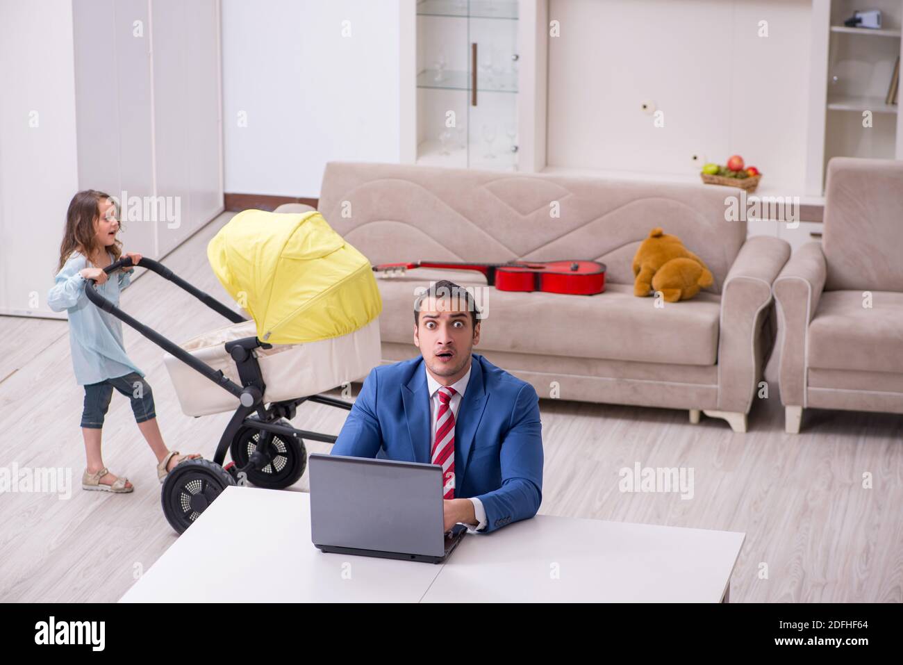 Young father of two children working from house Stock Photo - Alamy