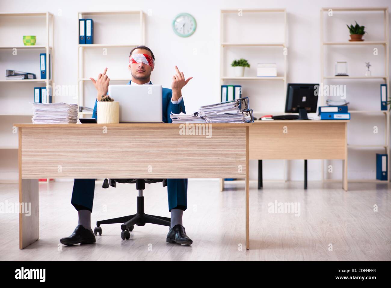 Blindfolded employee working in the office Stock Photo - Alamy