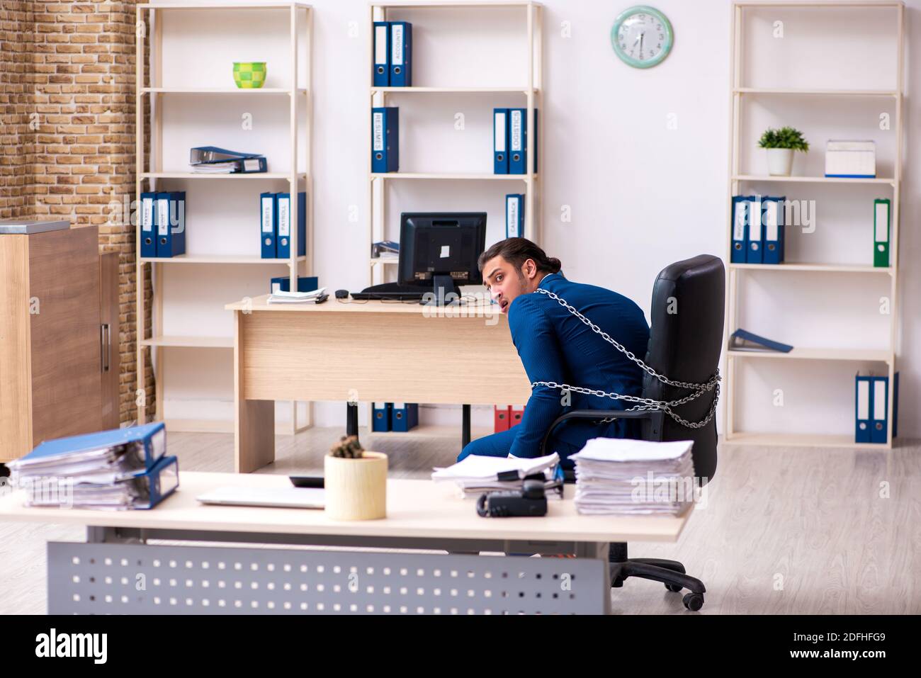 Chained employee working in the office Stock Photo - Alamy
