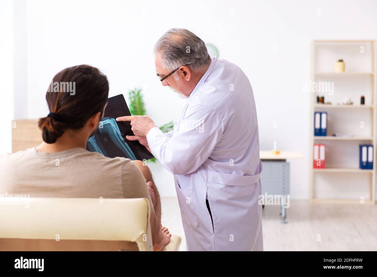 Young man visiting experienced doctor in hospital Stock Photo - Alamy