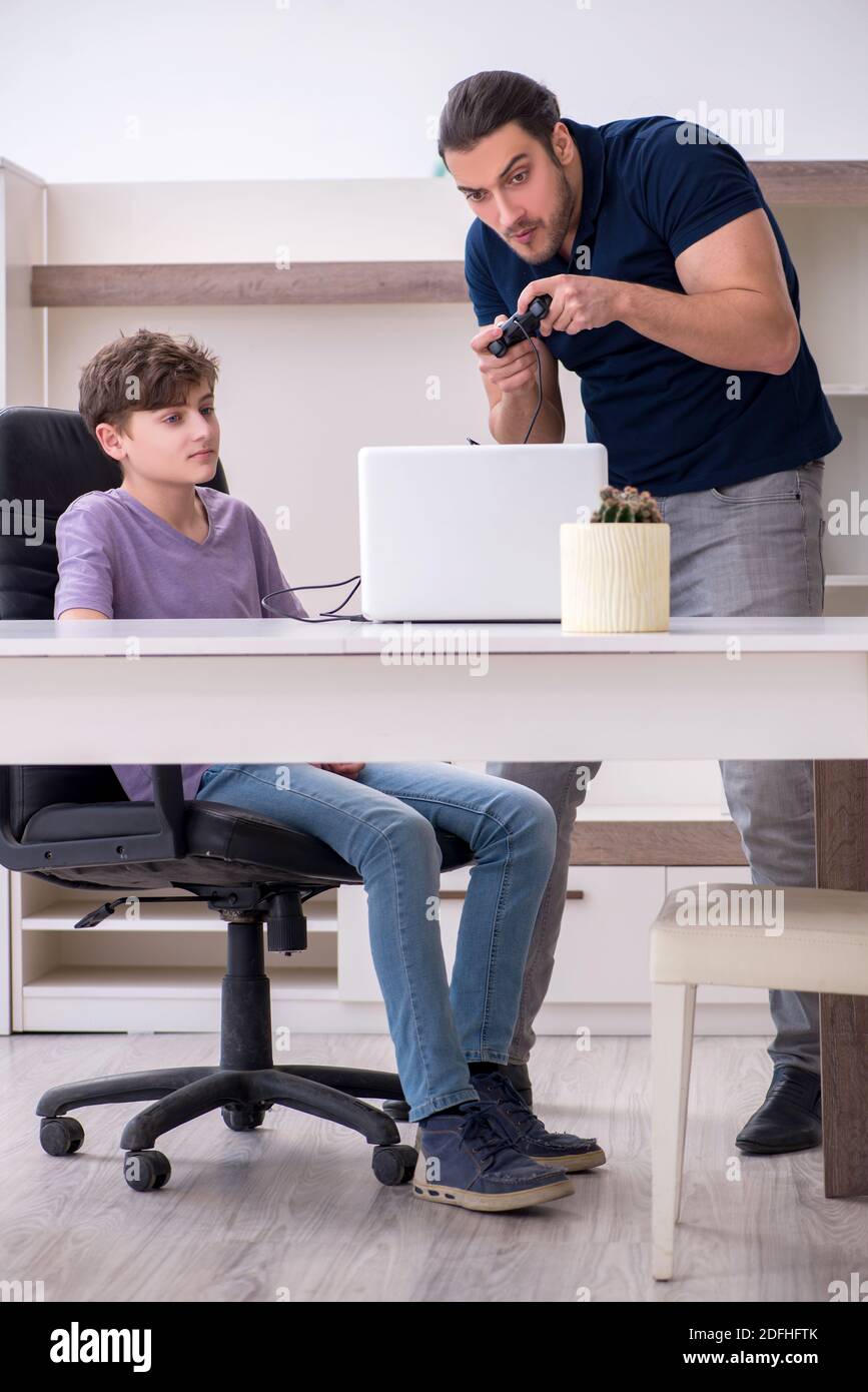 Father and schoolboy playing computer games at home Stock Photo - Alamy