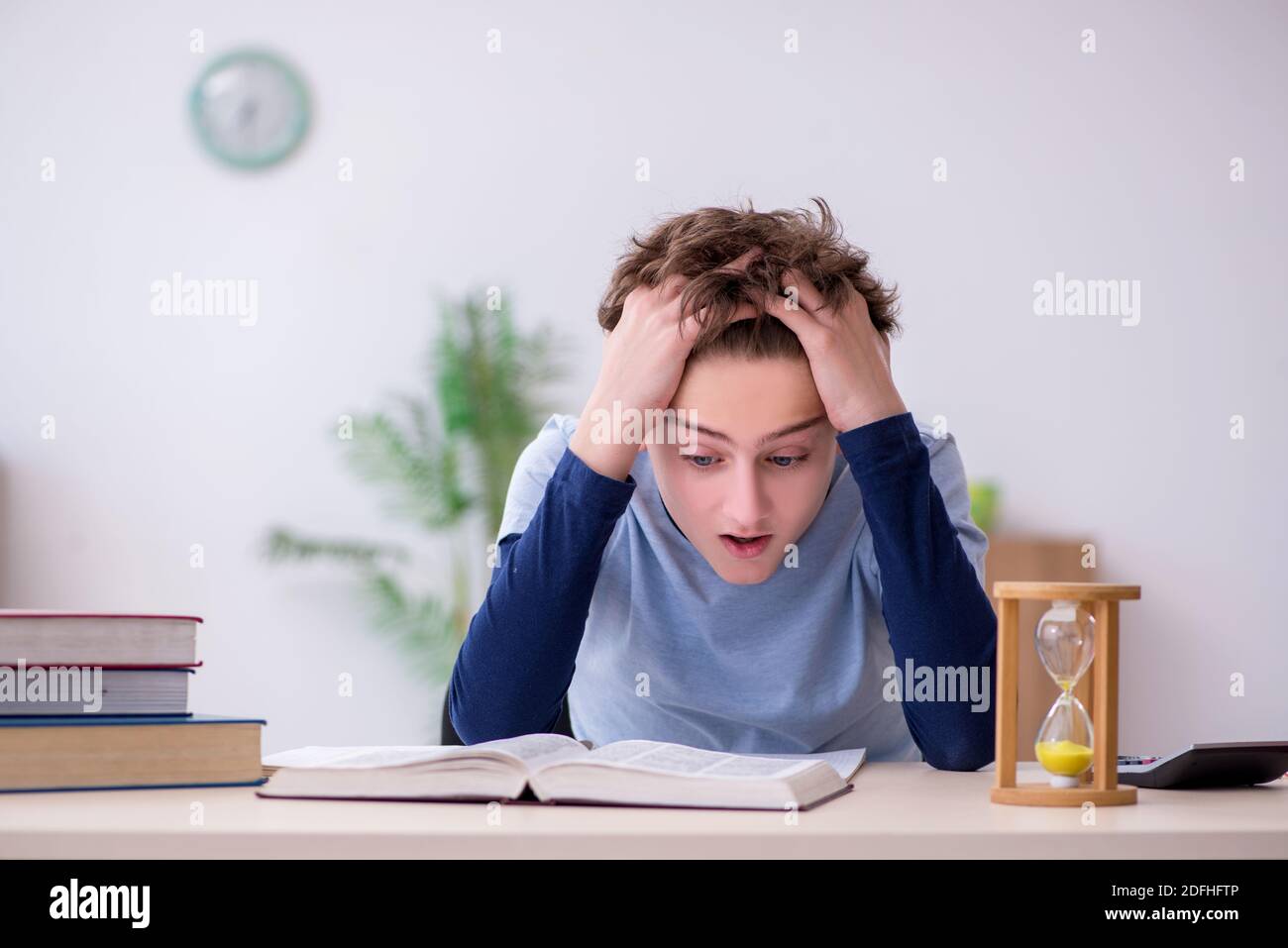 Boy preparing for exams in time management concept Stock Photo - Alamy