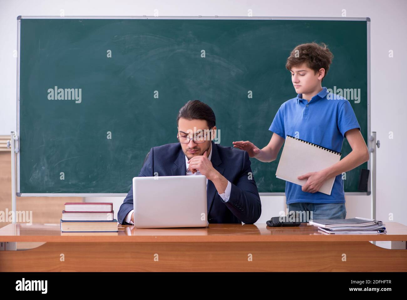 Male teacher and schoolboy in the classroom Stock Photo - Alamy