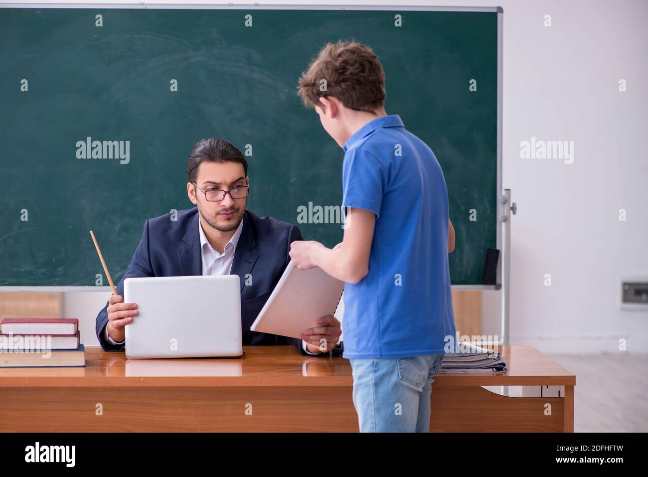 Male teacher and schoolboy in the classroom Stock Photo - Alamy