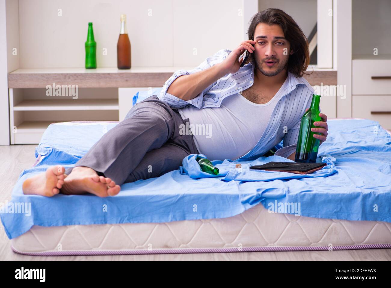 Male alcoholic in the bedroom Stock Photo - Alamy