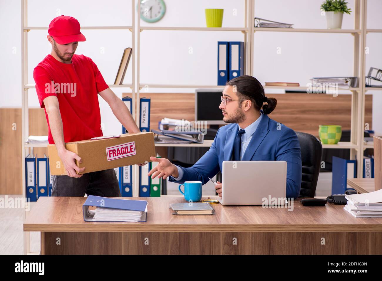 Man delivering parcel to the office Stock Photo - Alamy