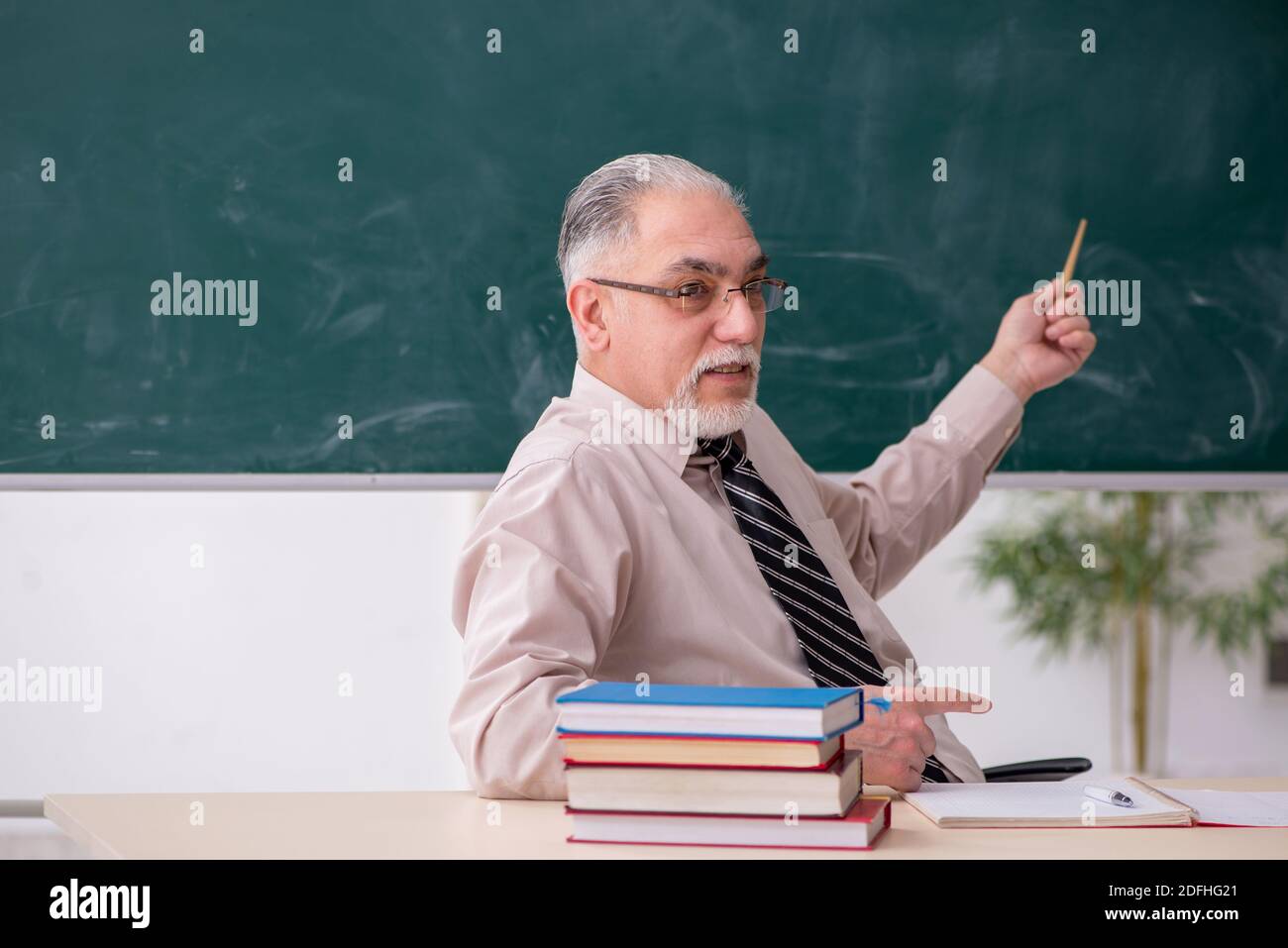 Old experienced teacher in the classroom Stock Photo - Alamy