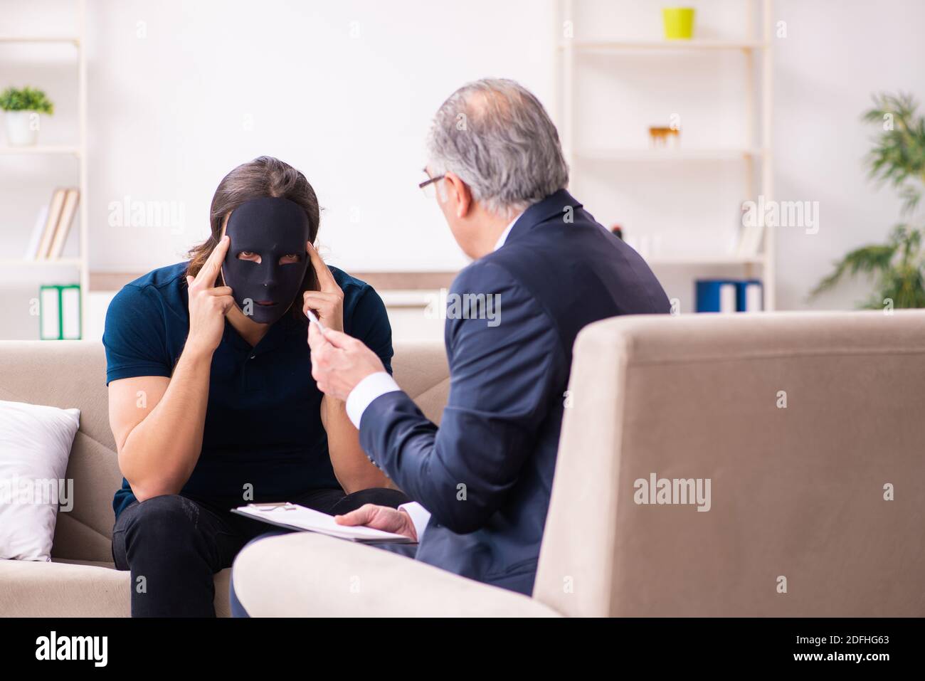 Man wearing masks during psychotherapy session Stock Photo - Alamy