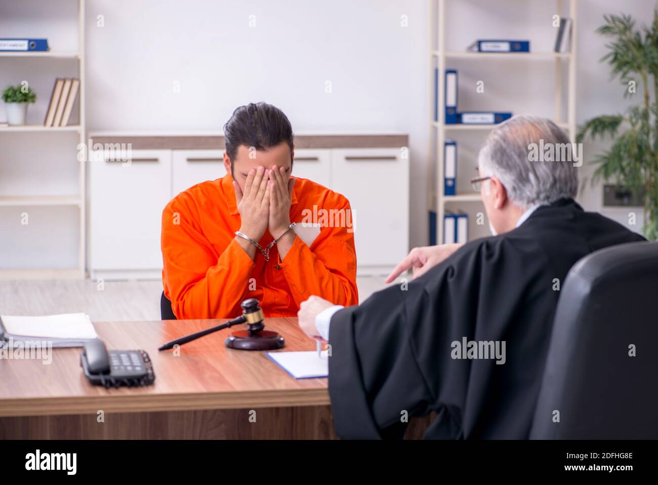 Old judge meeting with young captive in courthouse Stock Photo - Alamy
