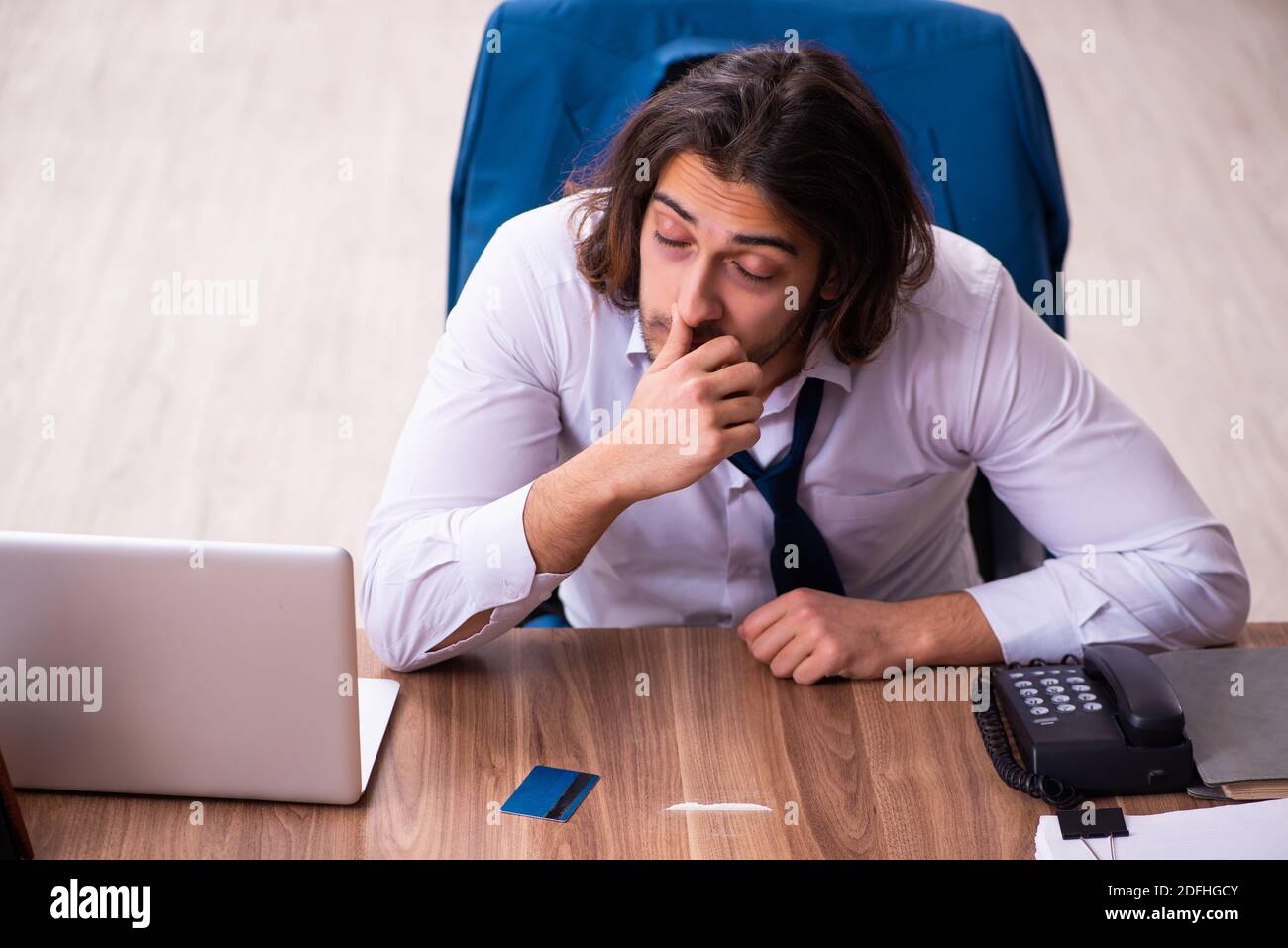 Drug addicted employee working in the office Stock Photo - Alamy