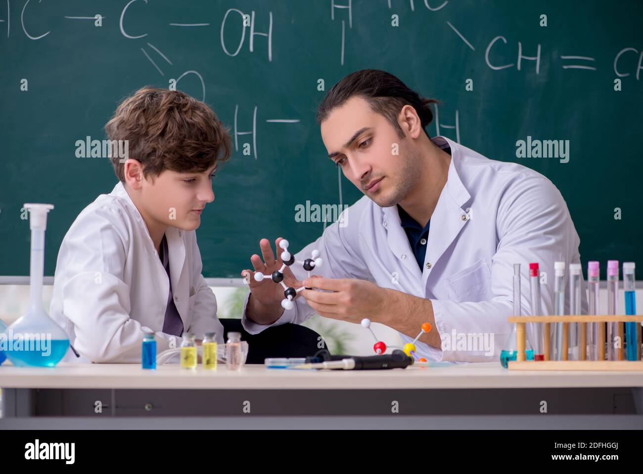 Young chemistry teacher and schoolboy in classroom Stock Photo - Alamy