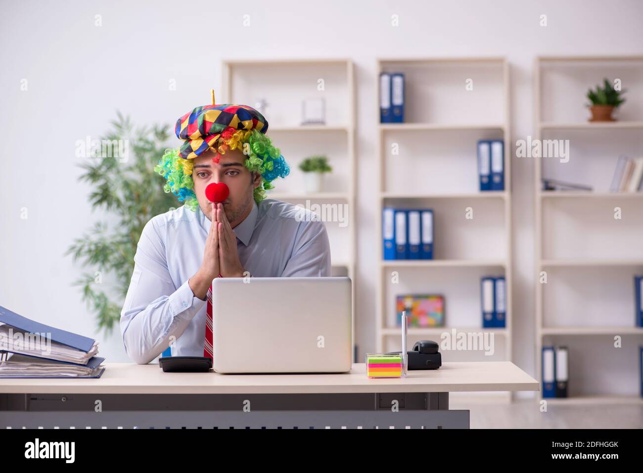 Funny employee clown working in the office room Stock Photo - Alamy