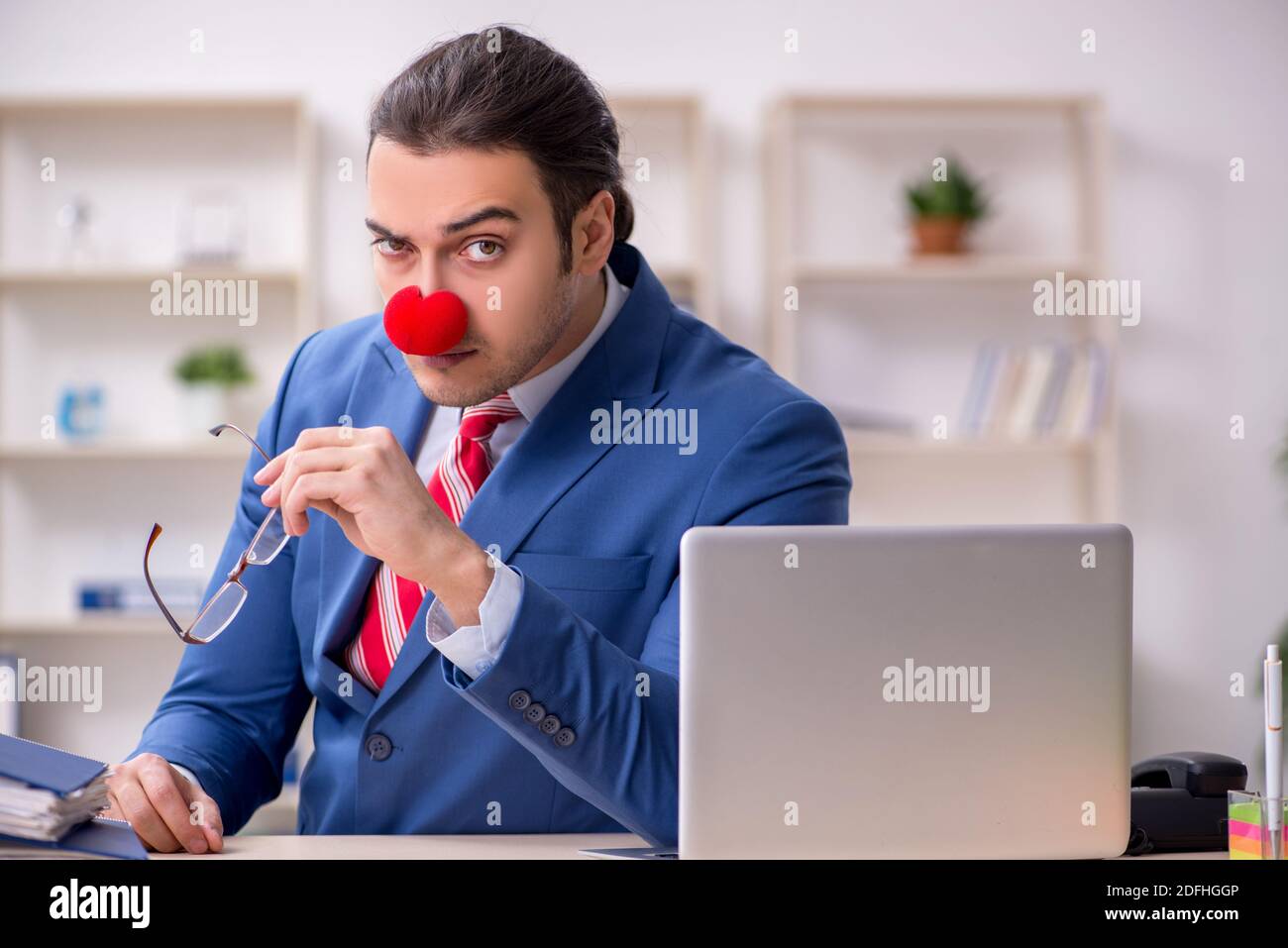 Funny employee clown working in the office room Stock Photo - Alamy